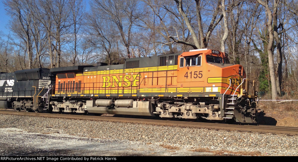 BNSF 4155 C44-9W leads NS 2637 SD70M and an intermodel train east across Church Street in ...